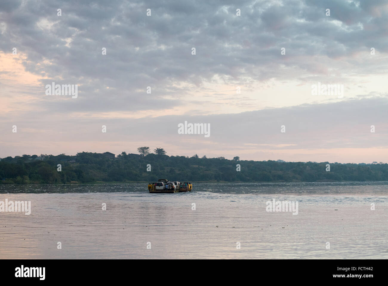 Ferry carrying vehicles and passengers across the River Nile near ...