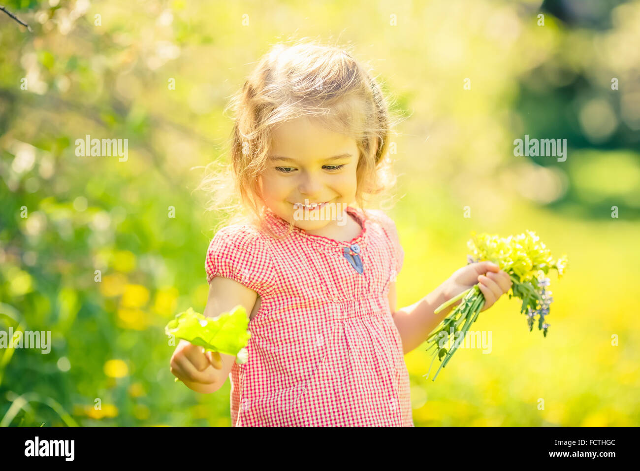 Happy little girl in spring sunny park Stock Photo - Alamy