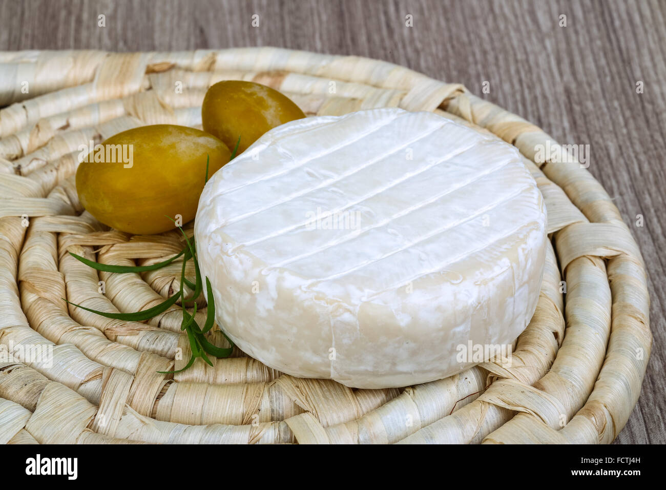Round Brie cheese with yellow plums and estragon Stock Photo - Alamy