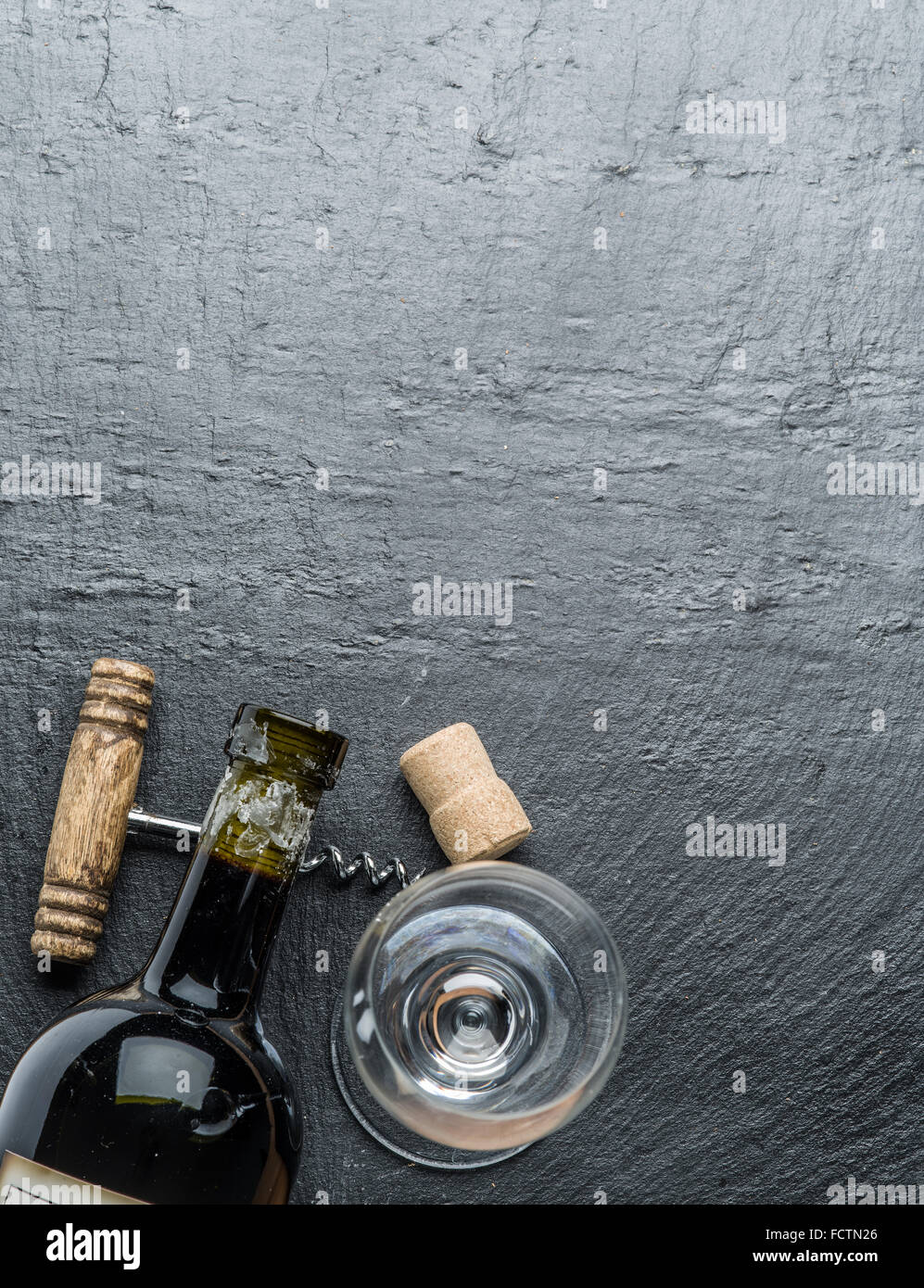 Wine bottle, wine glass and corkscrew on the graphite board Stock Photo ...