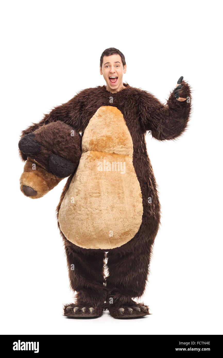 Full length portrait of a young joyful guy in a bear costume giving a ...