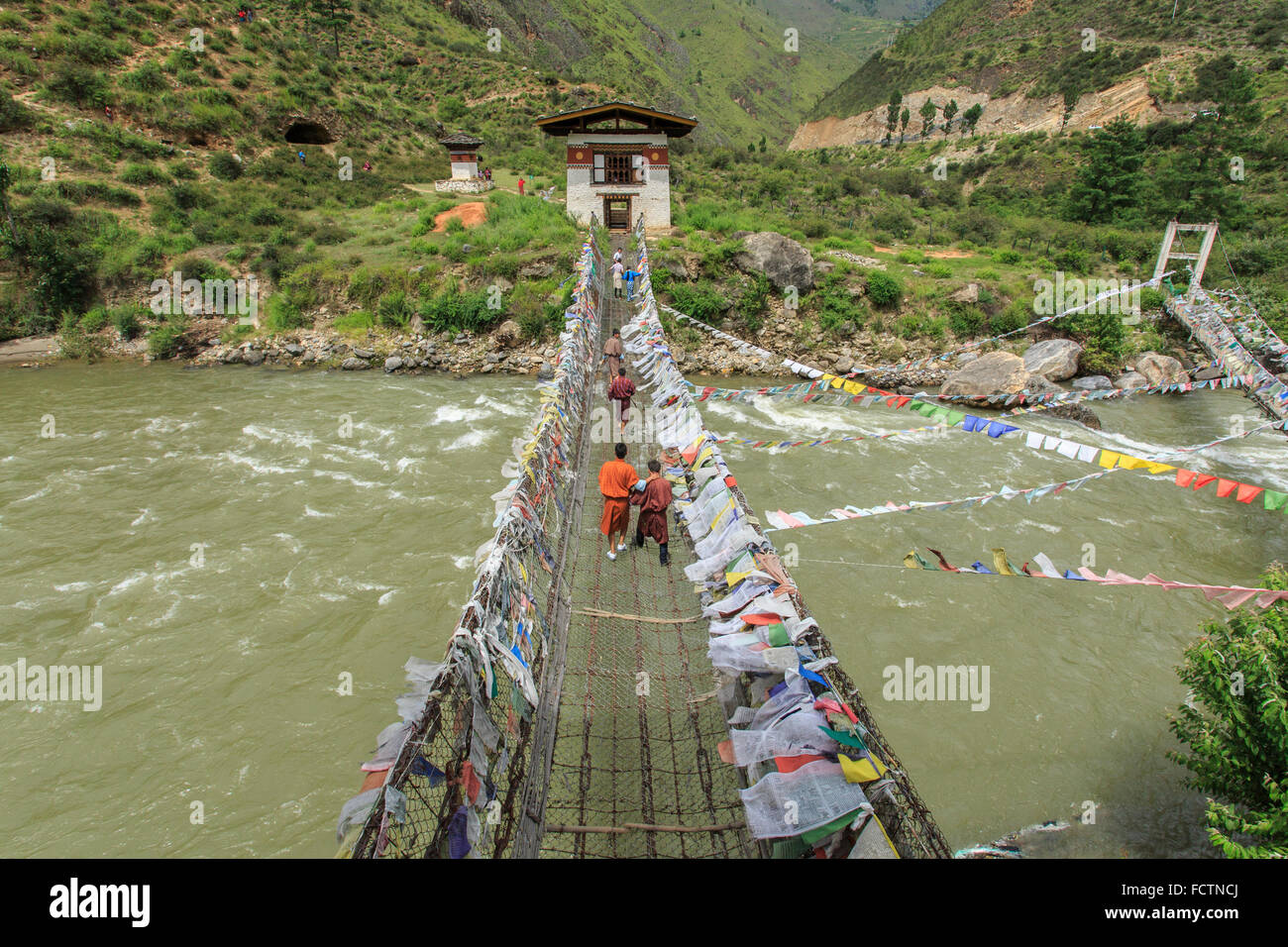 People crossing a wire suspension bridge in Bhutan Stock Photo - Alamy