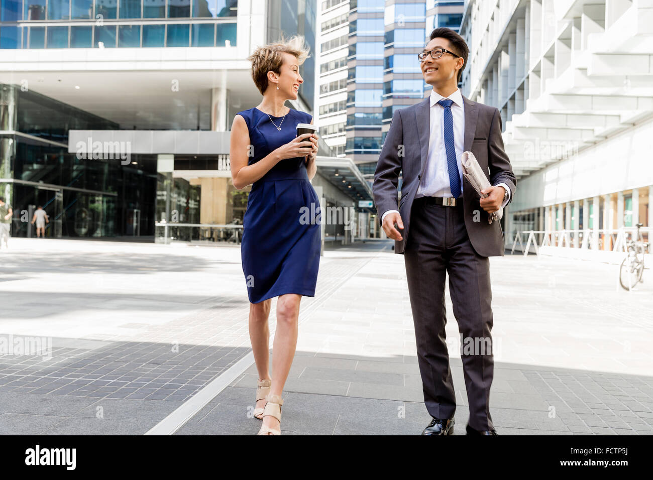 Business people having a talk while walking in a businesss district ...