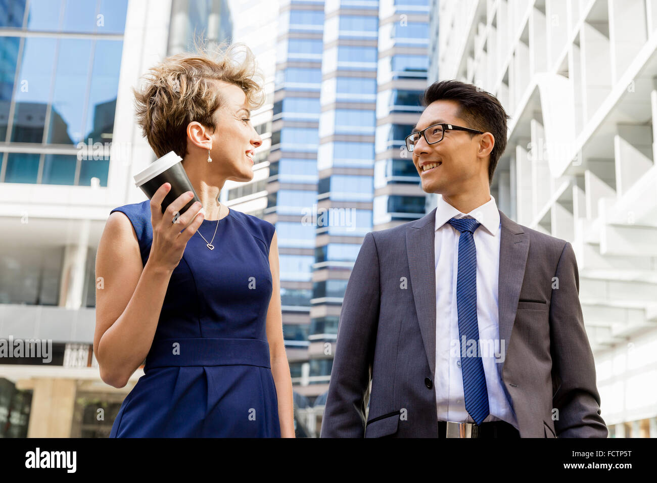Business people having a talk while walking in a businesss district ...