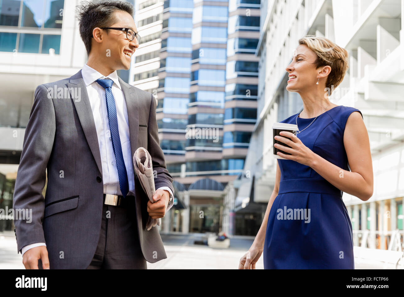 Business people having a talk while walking in a businesss district ...