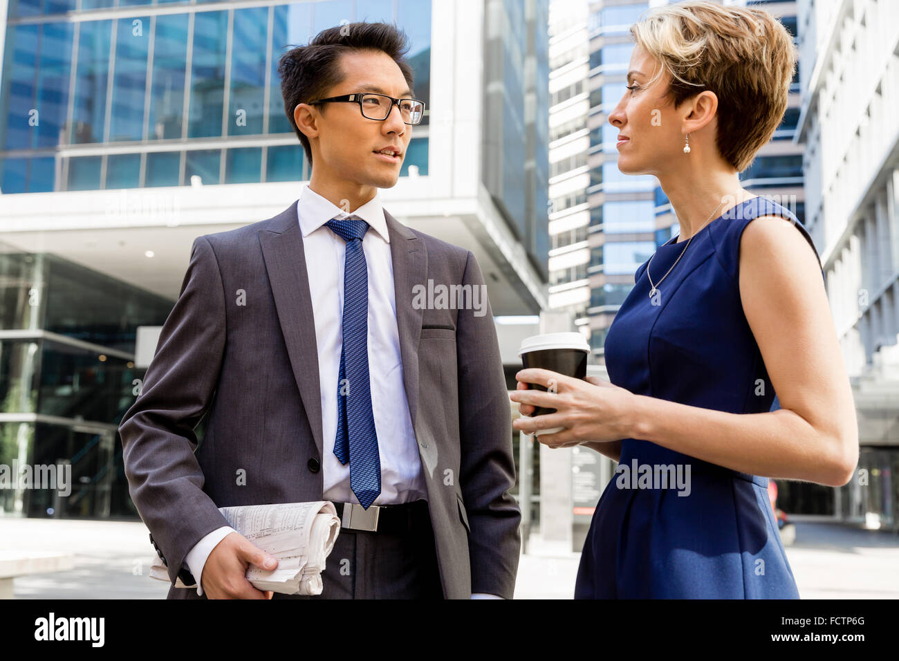 Business people having a talk while walking in a businesss district ...