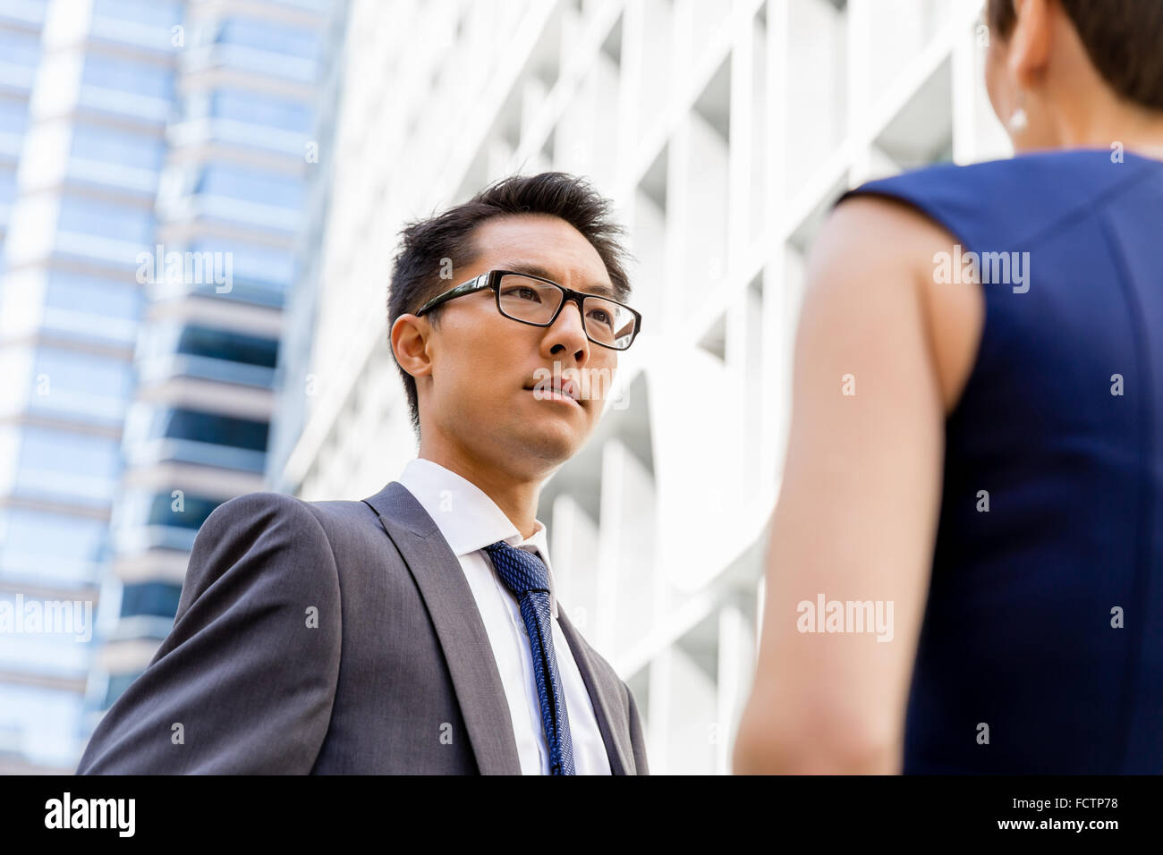 Business people having a talk while walking in a businesss district ...