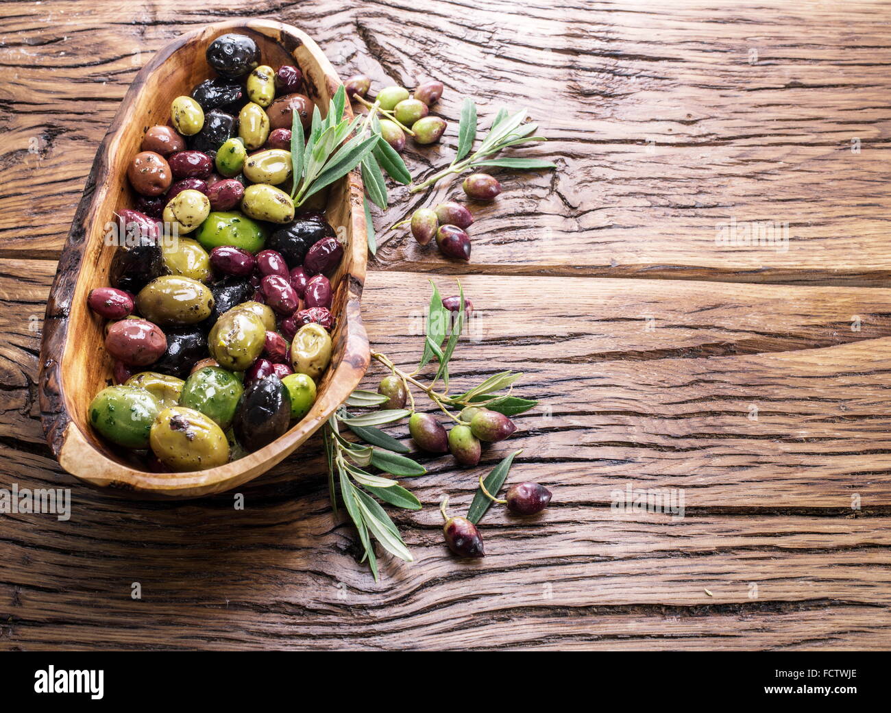 Whole table olives in the wooden bowl on the table Stock Photo - Alamy