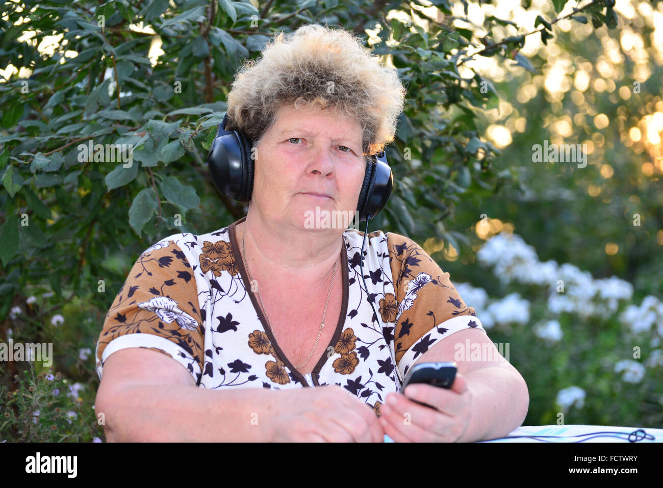 Mature woman listening to music Stock Photo - Alamy
