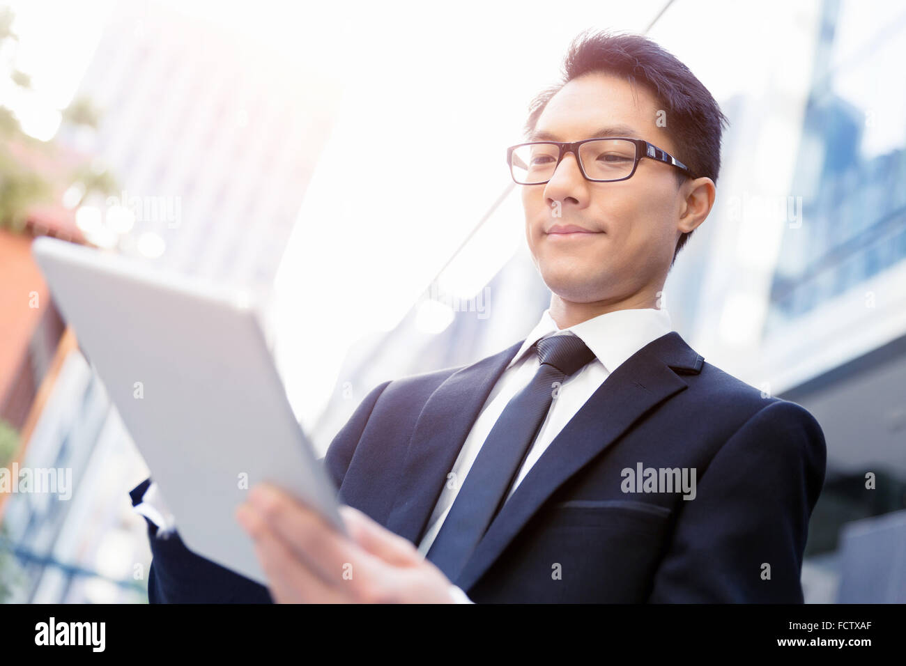 Businessman in city holding his notebook Stock Photo - Alamy