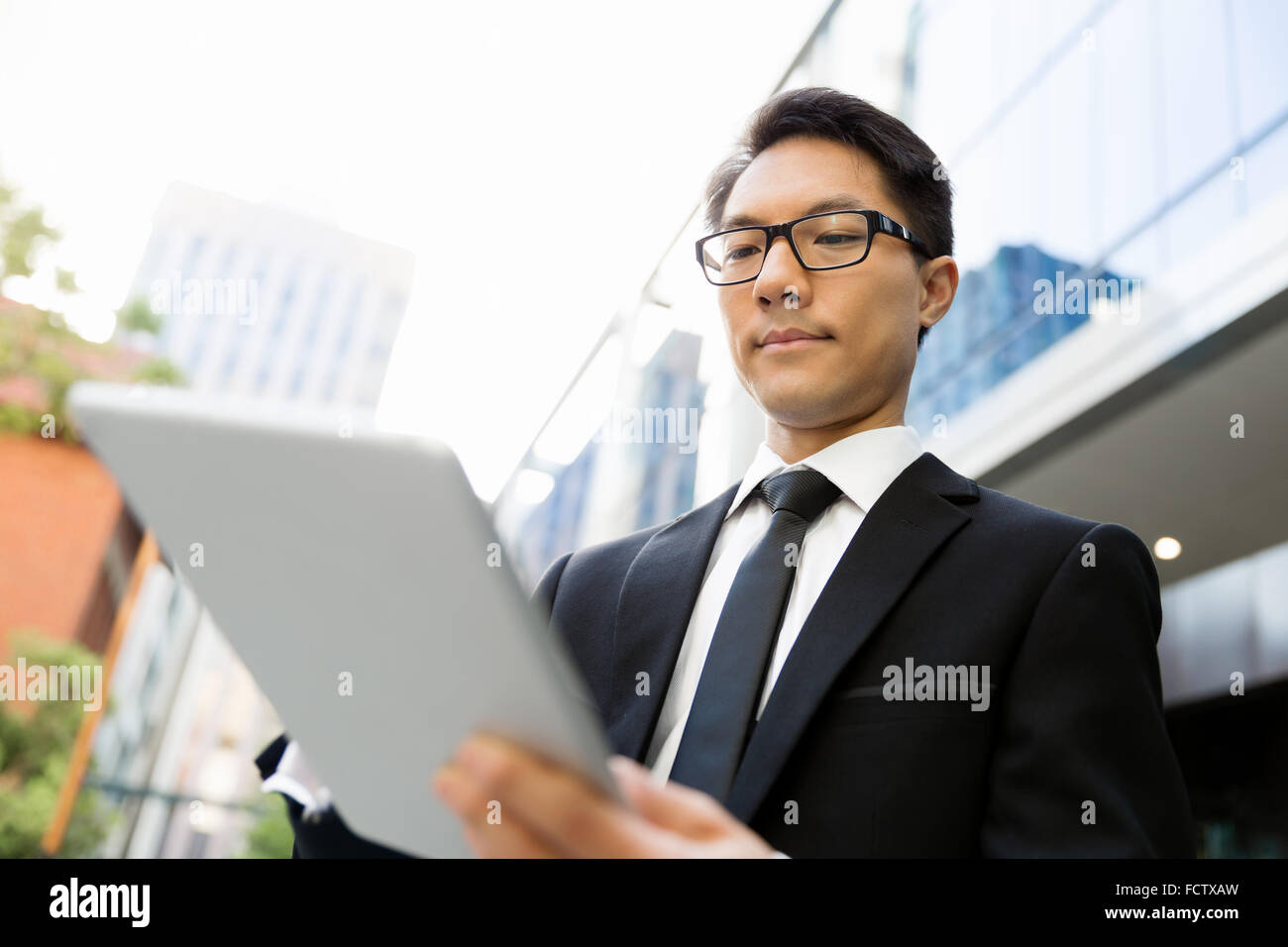 Businessman in city holding his notebook Stock Photo - Alamy