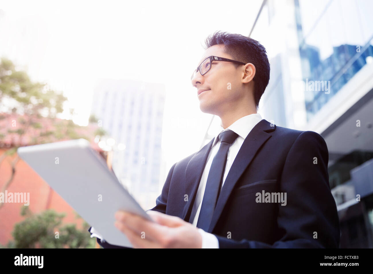 Businessman in city holding his notebook Stock Photo - Alamy