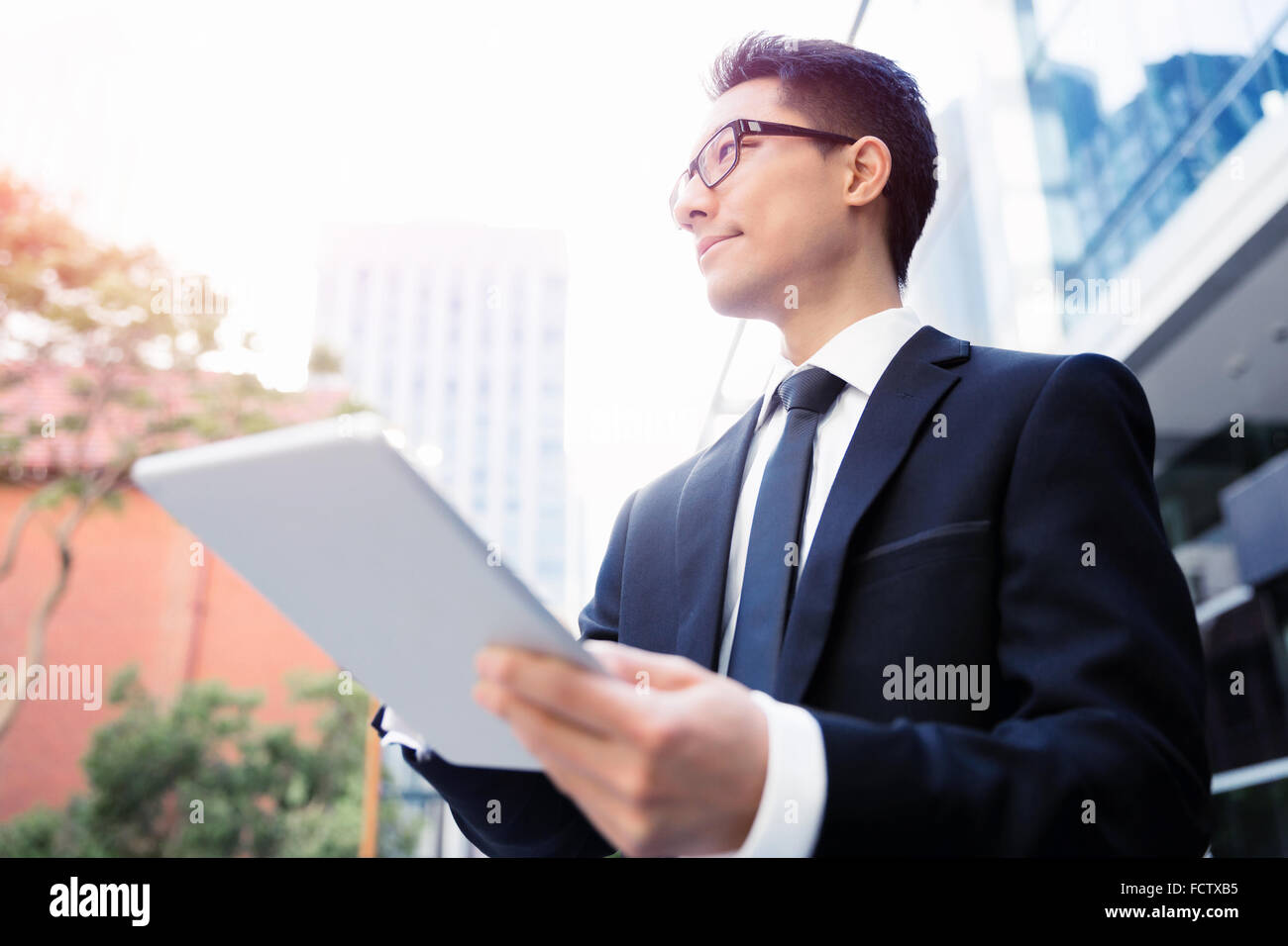 Businessman in city holding his notebook Stock Photo - Alamy