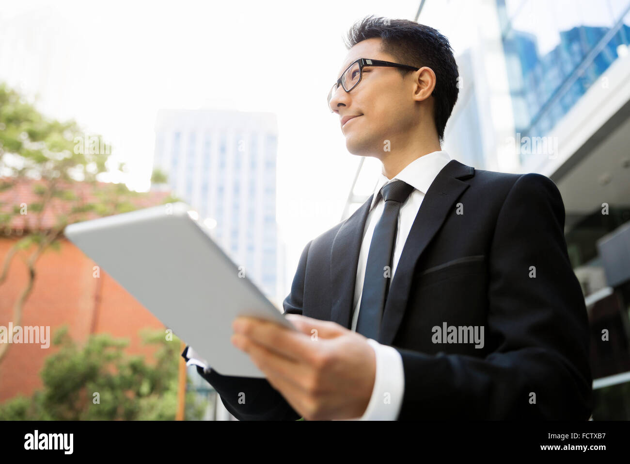 Businessman in city holding his notebook Stock Photo - Alamy