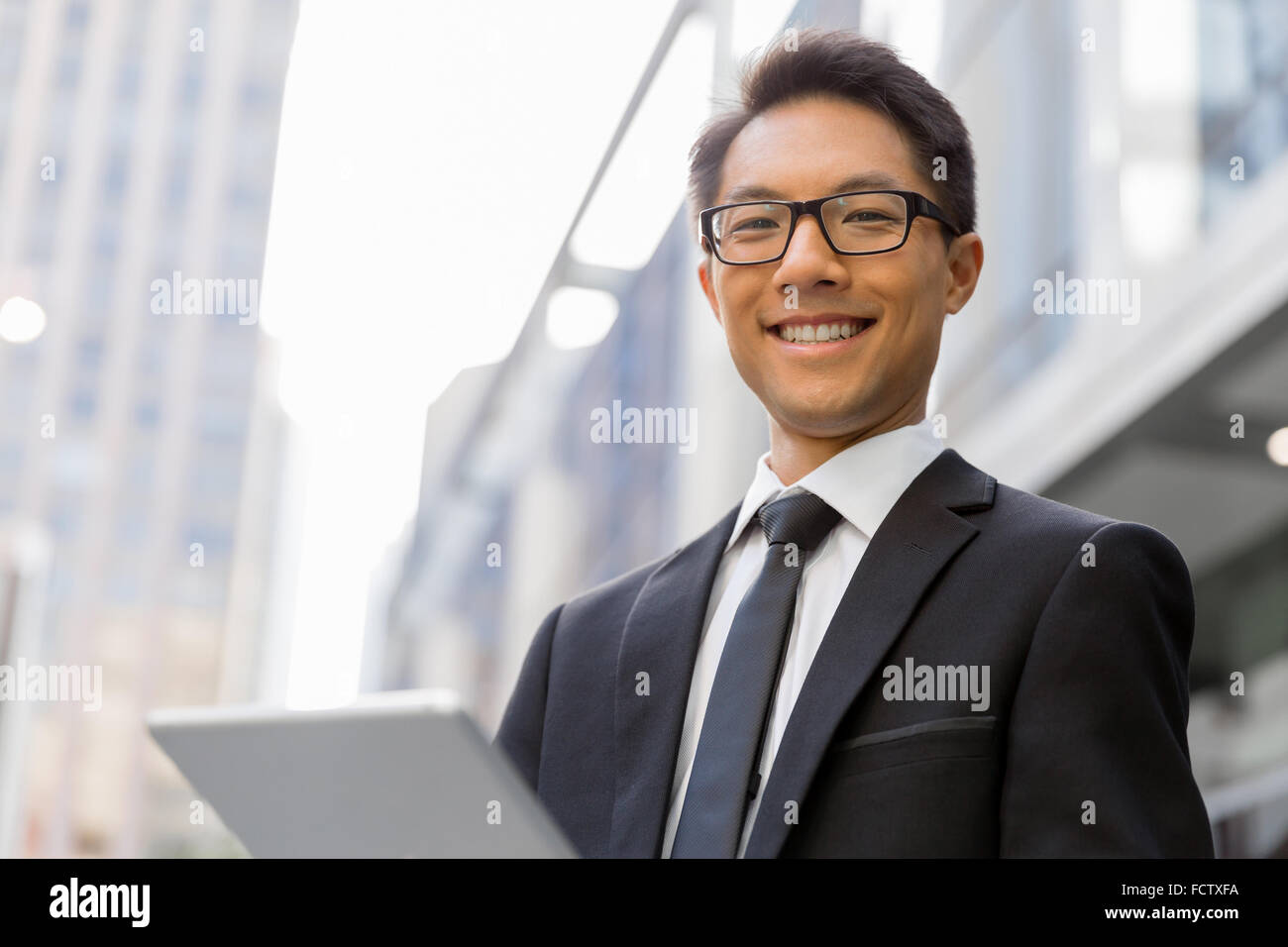 Businessman in city holding his notebook Stock Photo - Alamy