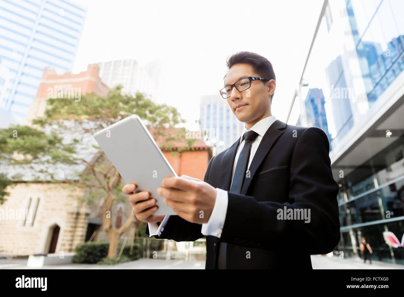 Businessman in city holding his notebook Stock Photo - Alamy