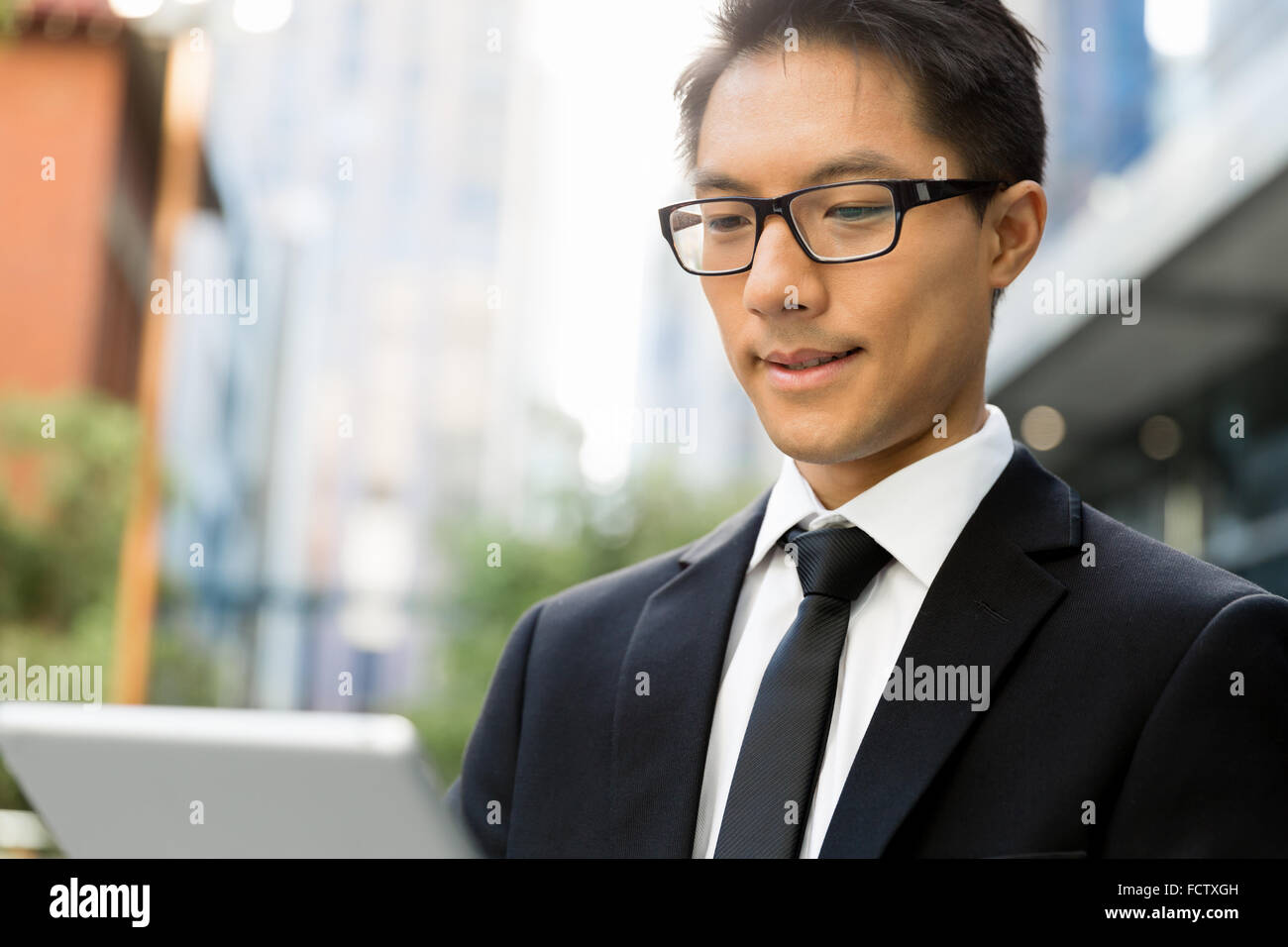 Businessman in city holding his notebook Stock Photo - Alamy