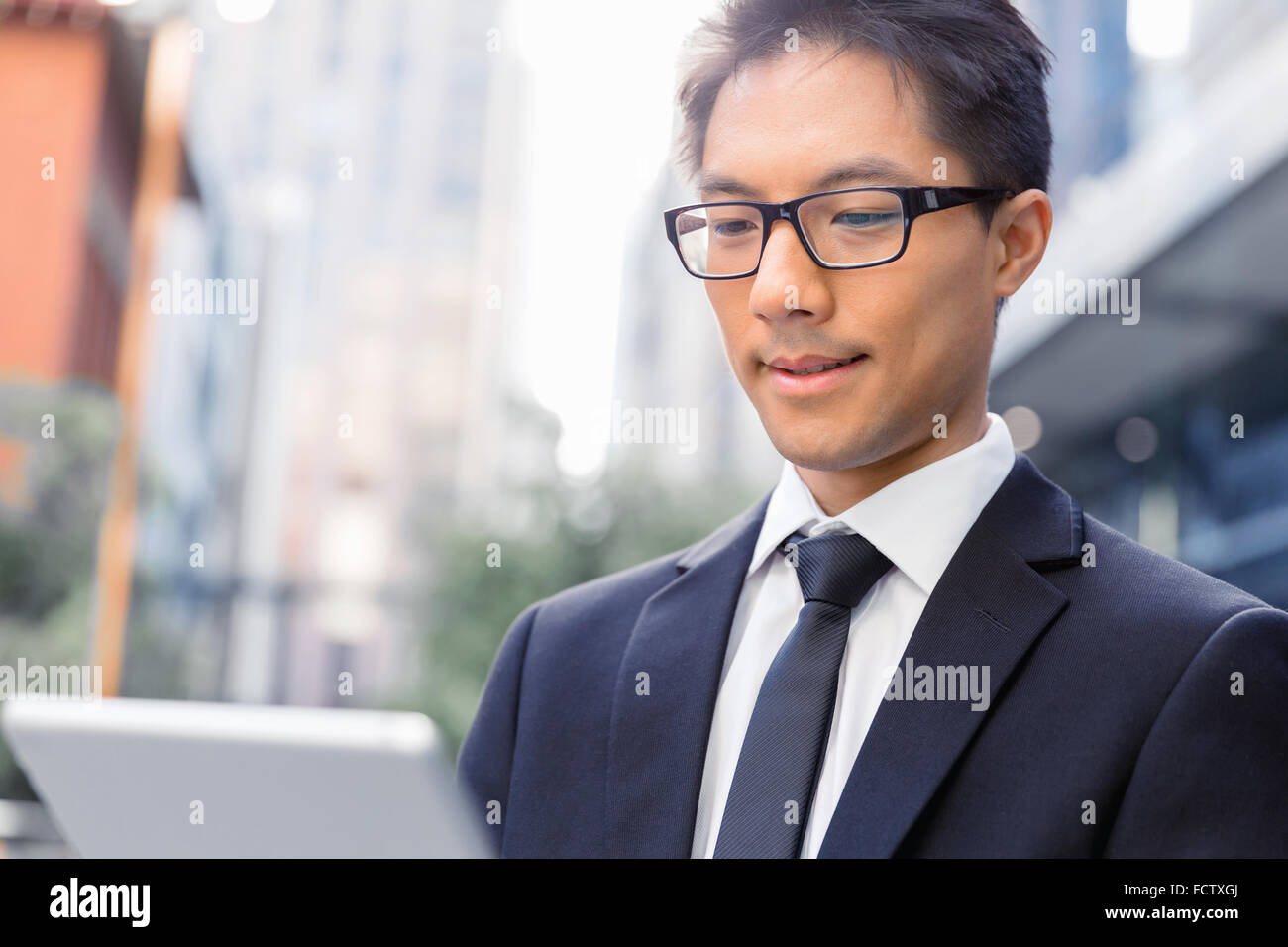 Businessman in city holding his notebook Stock Photo - Alamy