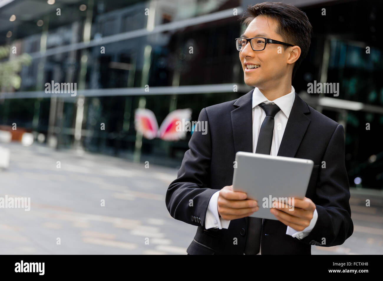 Businessman in city holding his notebook Stock Photo - Alamy