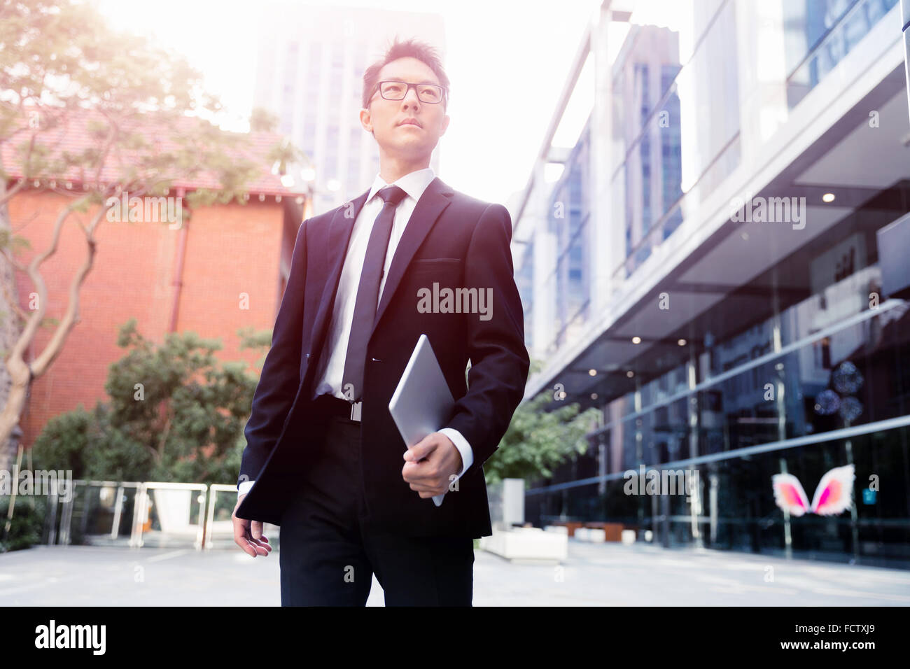 Businessman in city holding his notebook Stock Photo - Alamy