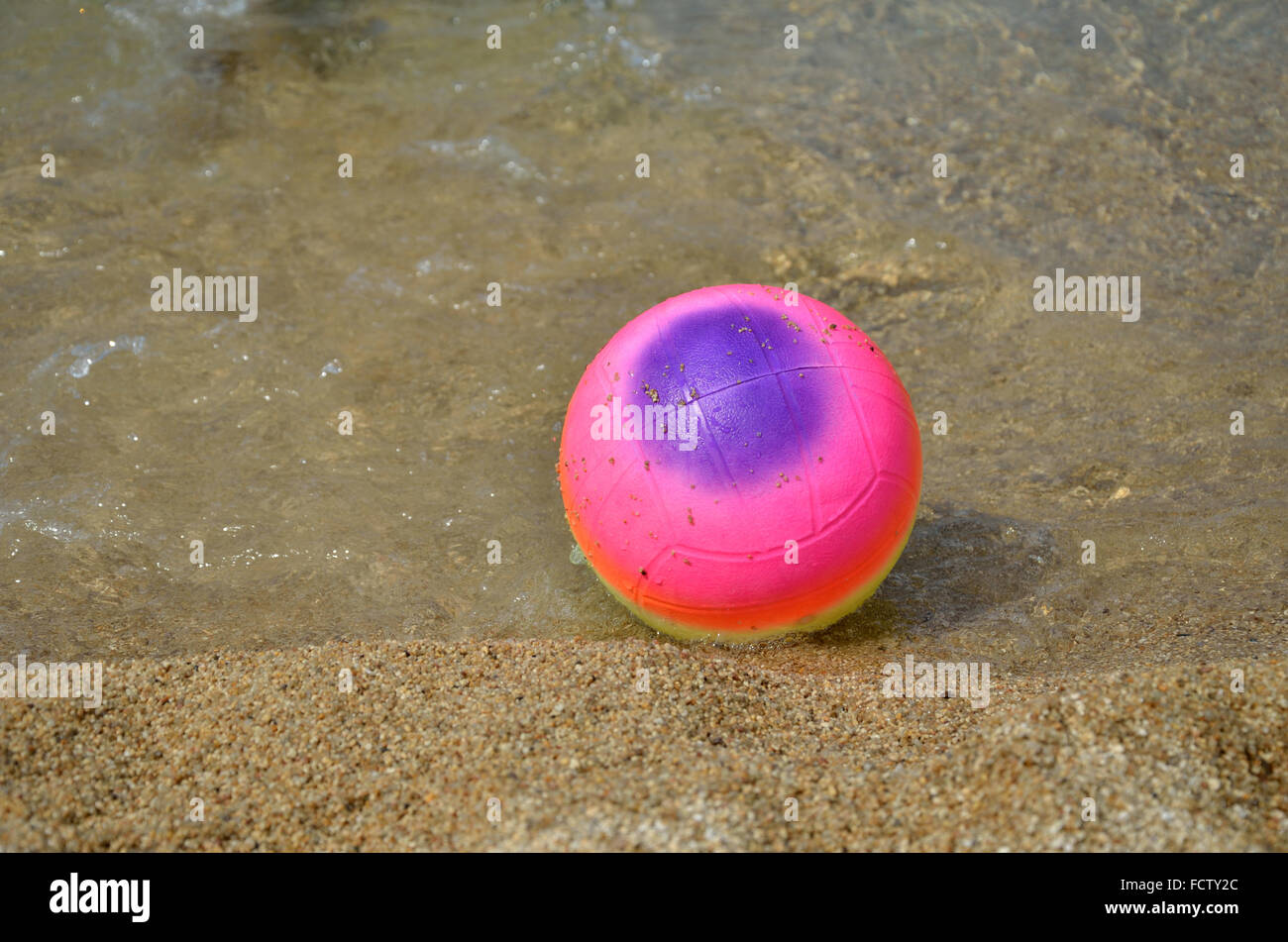 Colorful beach ball in shallow sea water Stock Photo - Alamy