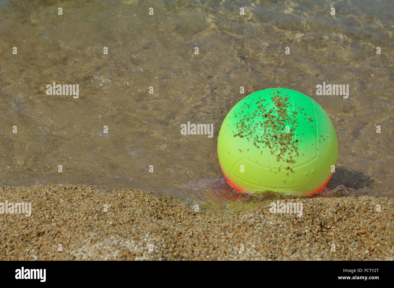 Colorful beach ball with wet sand in shallow sea water Stock Photo - Alamy