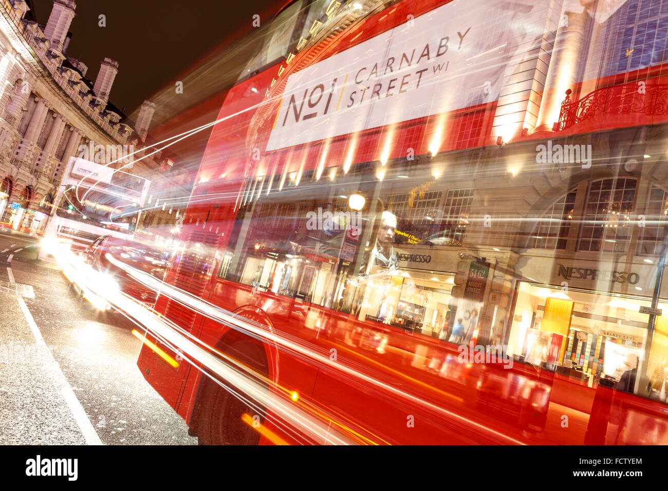 Red bus on the Regent Street in London. Blurry lights from long shutter ...