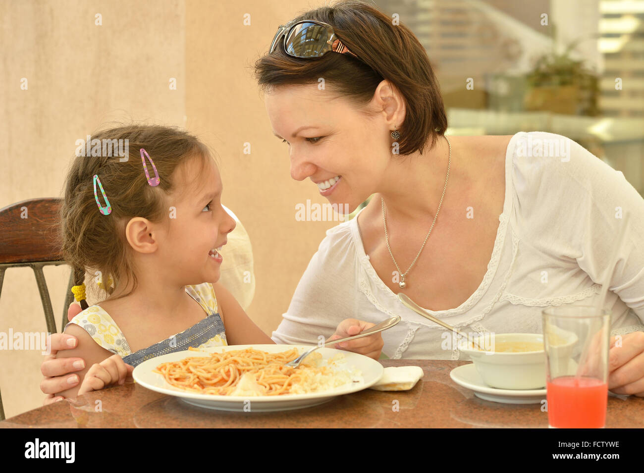 girl with mother eating at table Stock Photo - Alamy