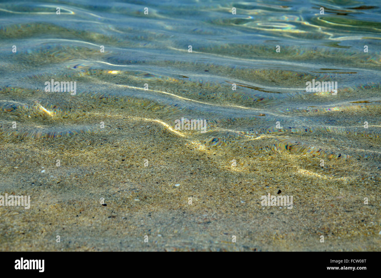 Sparkling ripple transparent turquoise sea water with seabed below ...