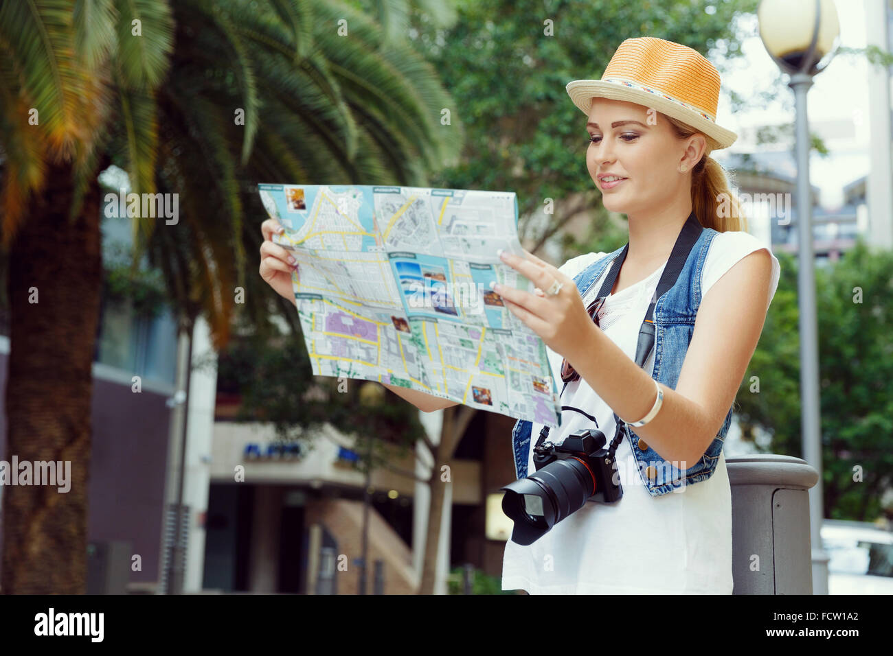 Happy young woman with a map Stock Photo - Alamy
