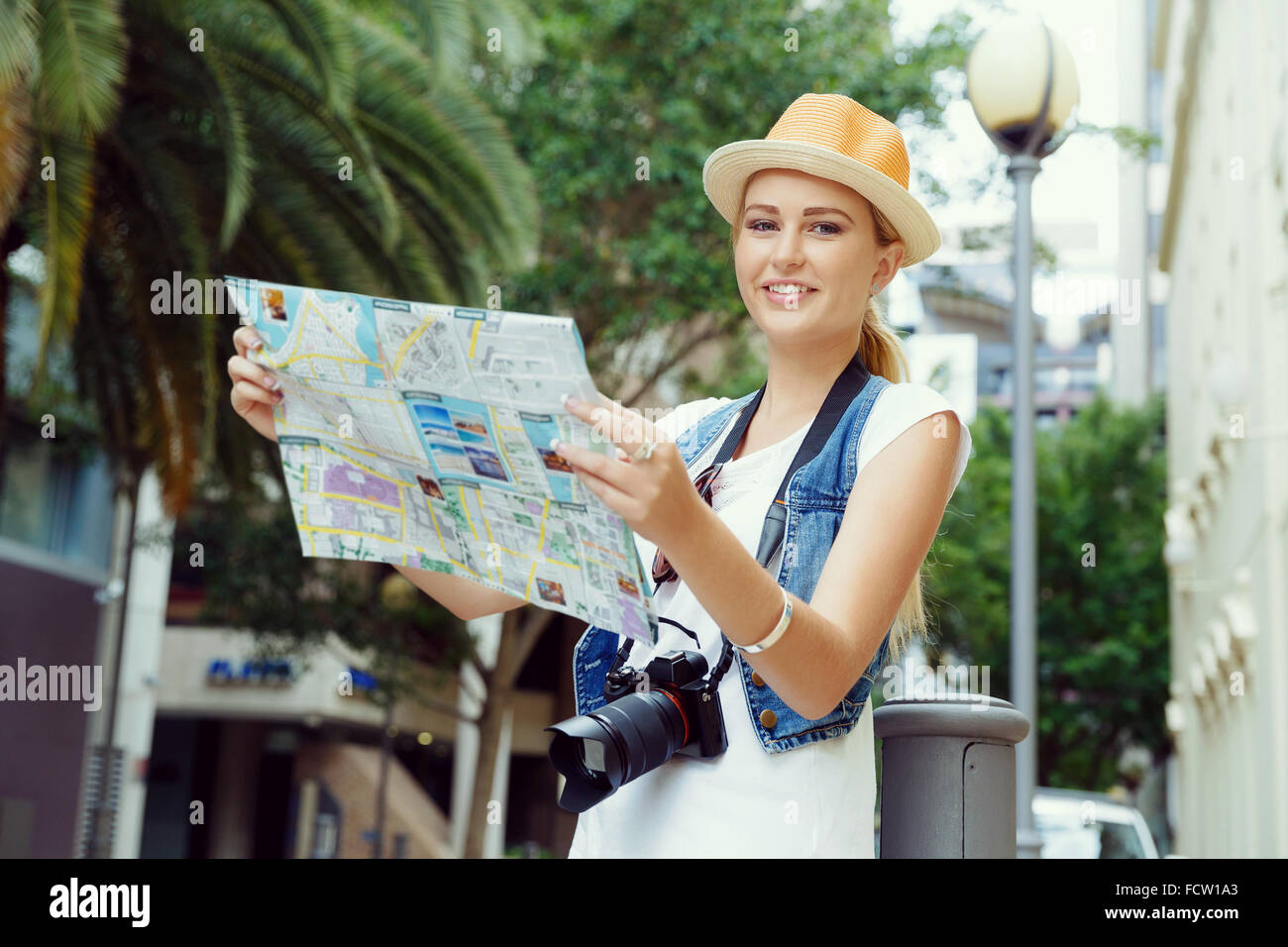 Happy young woman with a map Stock Photo - Alamy