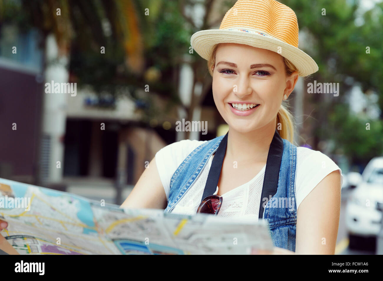 Happy young woman with a map Stock Photo - Alamy