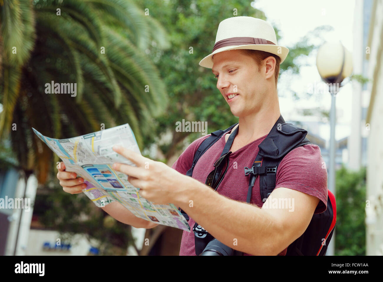 Happy young man with a map Stock Photo - Alamy