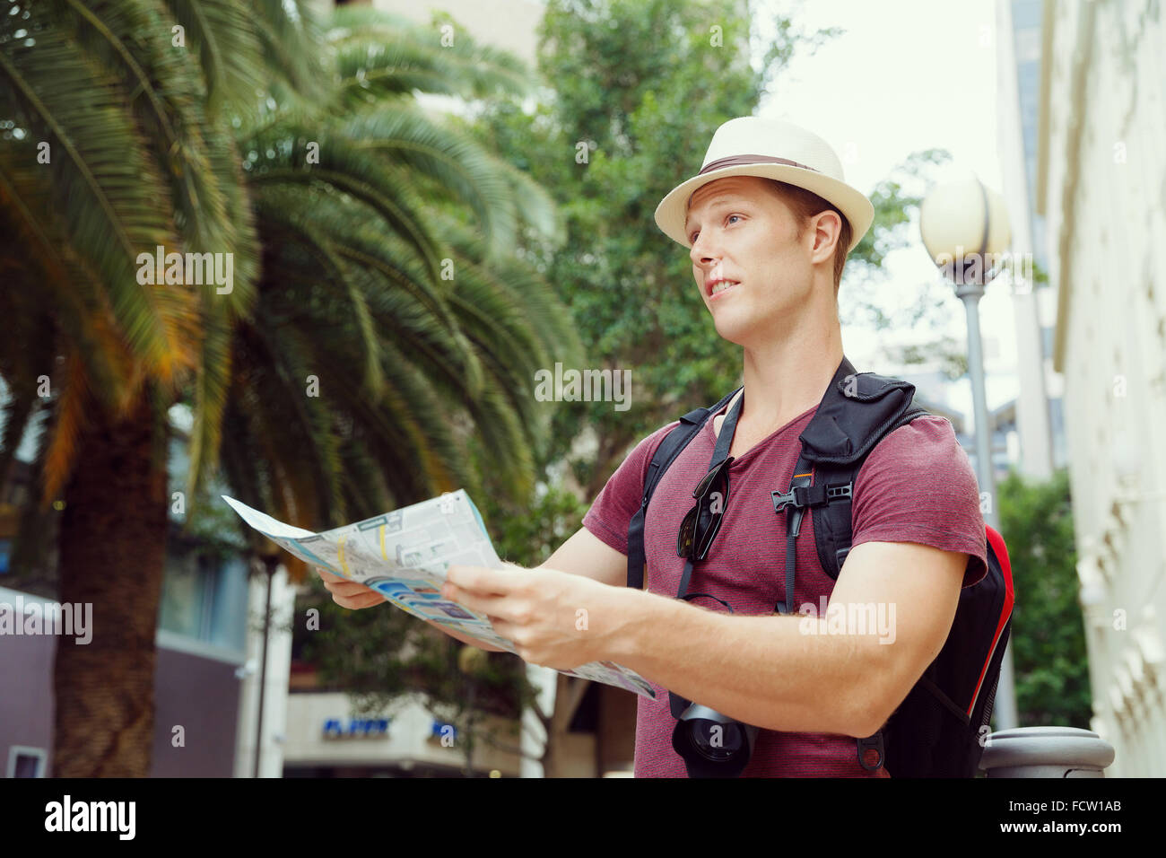 Happy young man with a map Stock Photo - Alamy