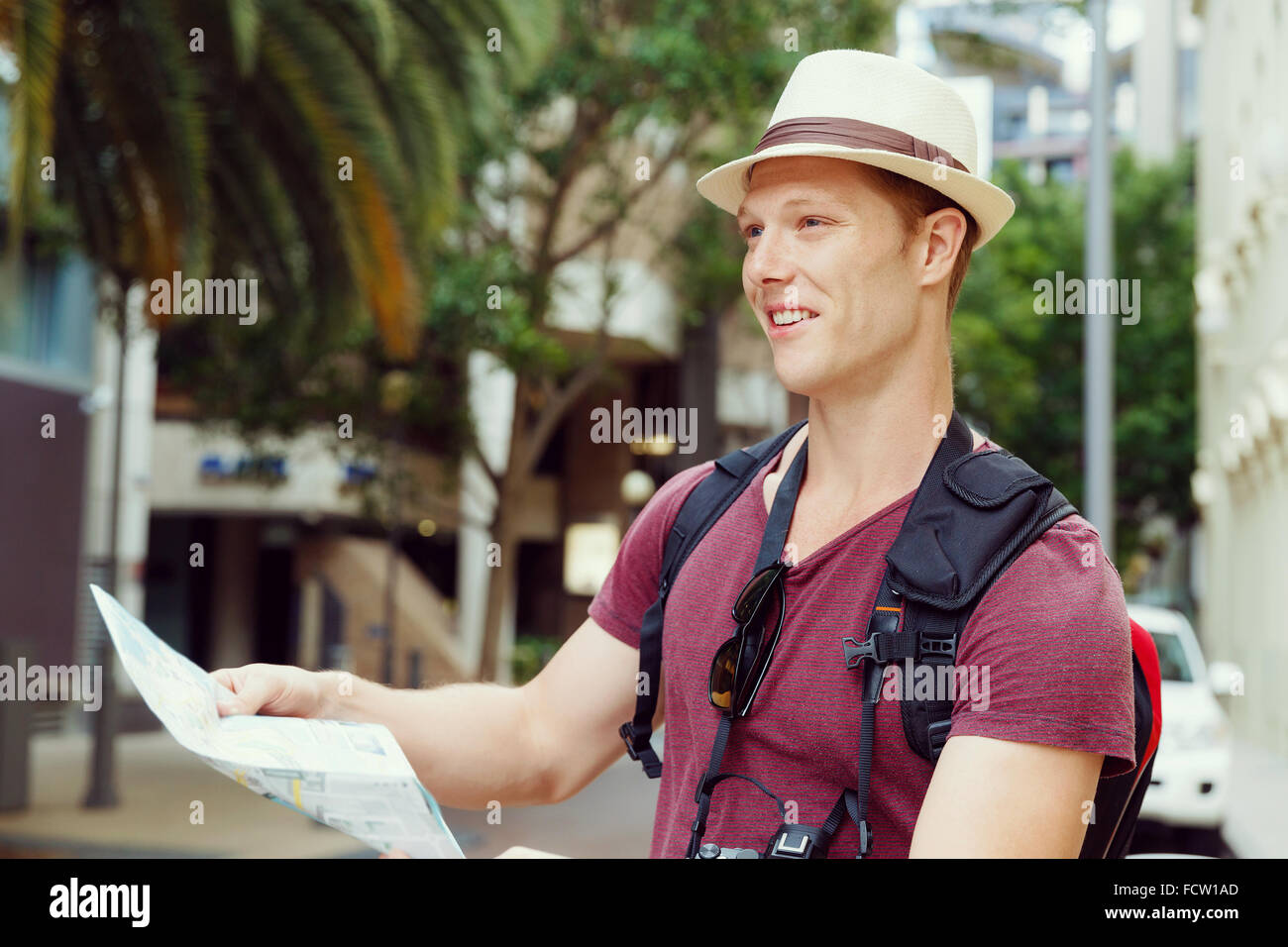 Happy young man with a map Stock Photo - Alamy