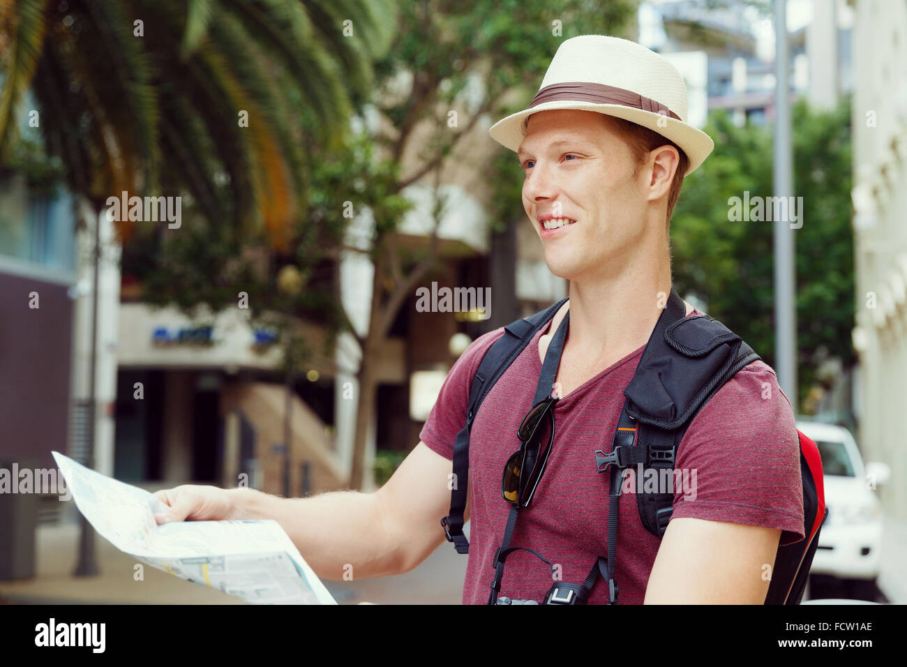 Happy young man with a map Stock Photo - Alamy