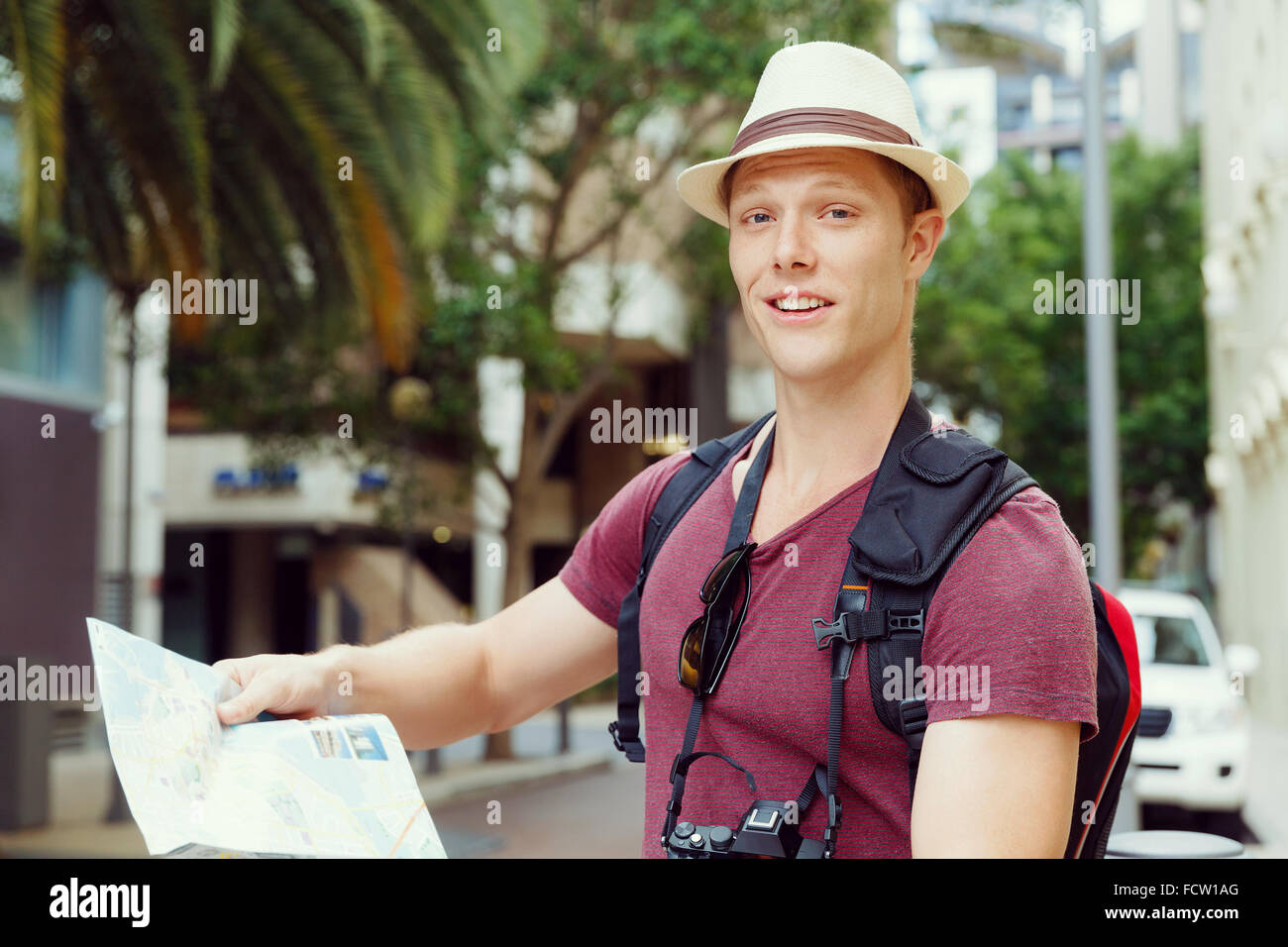 Happy young man with a map Stock Photo - Alamy