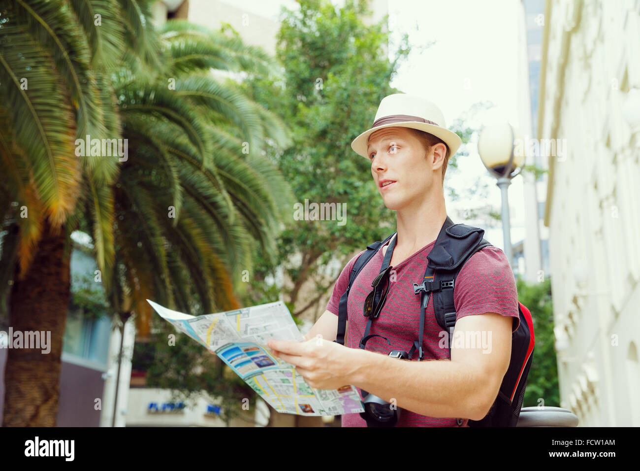 Happy young man with a map Stock Photo - Alamy