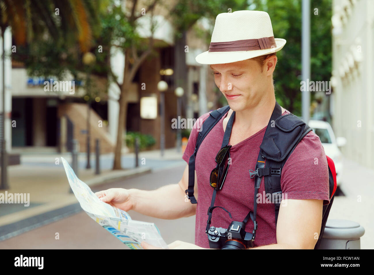 Happy young man with a map Stock Photo - Alamy