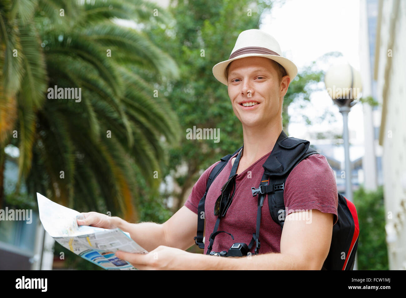 Happy young man with a map Stock Photo - Alamy