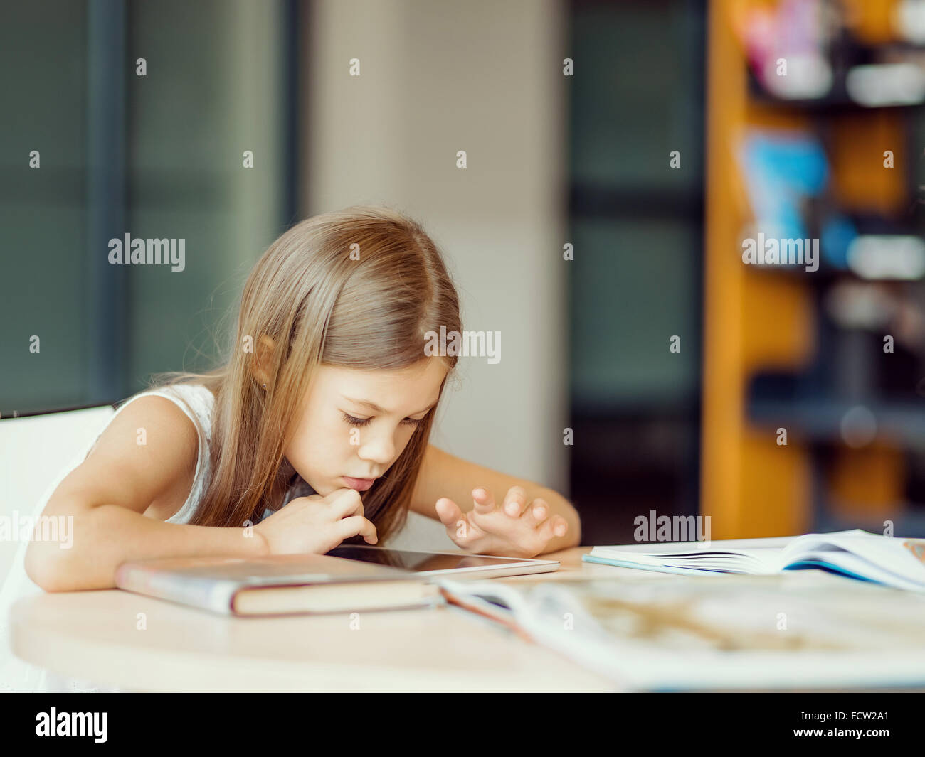 Girl doing her homework in library Stock Photo - Alamy