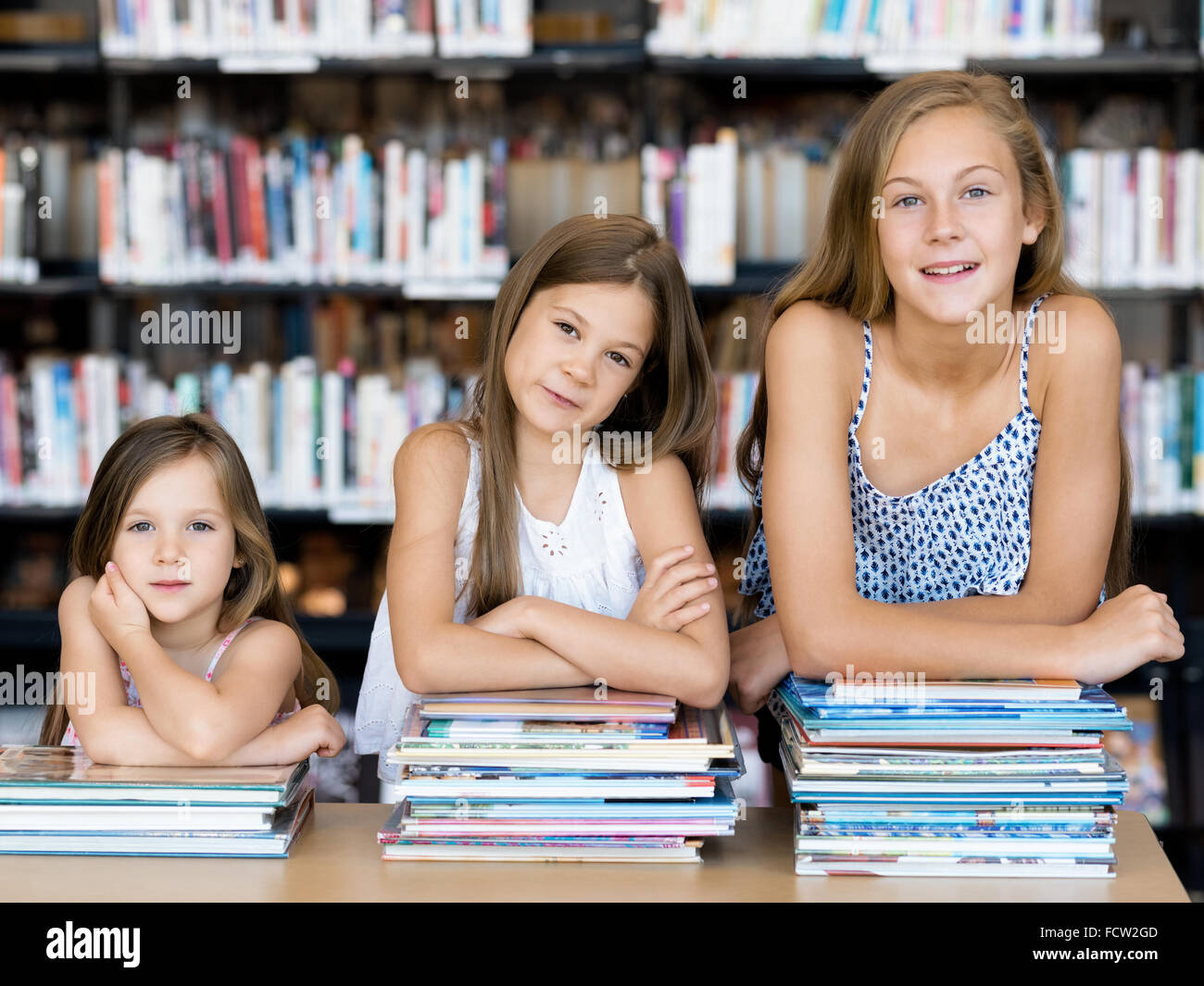 Little girls reading books in library Stock Photo - Alamy