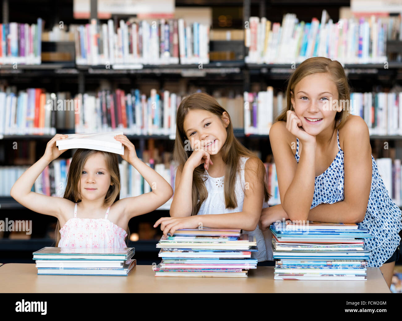 Little girls reading books in library Stock Photo - Alamy