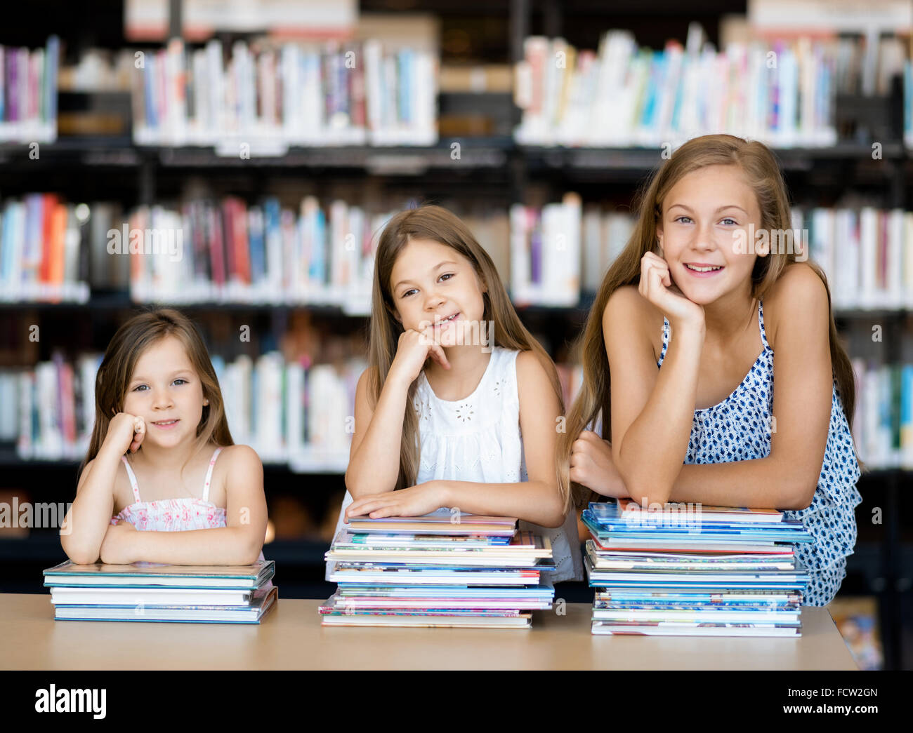 Little girls reading books in library Stock Photo - Alamy