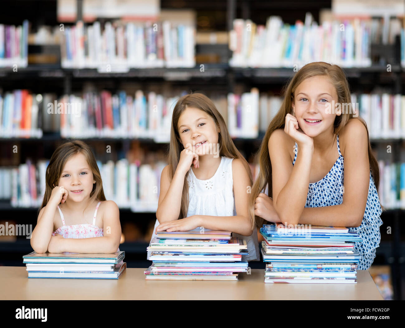Little girls reading books in library Stock Photo - Alamy