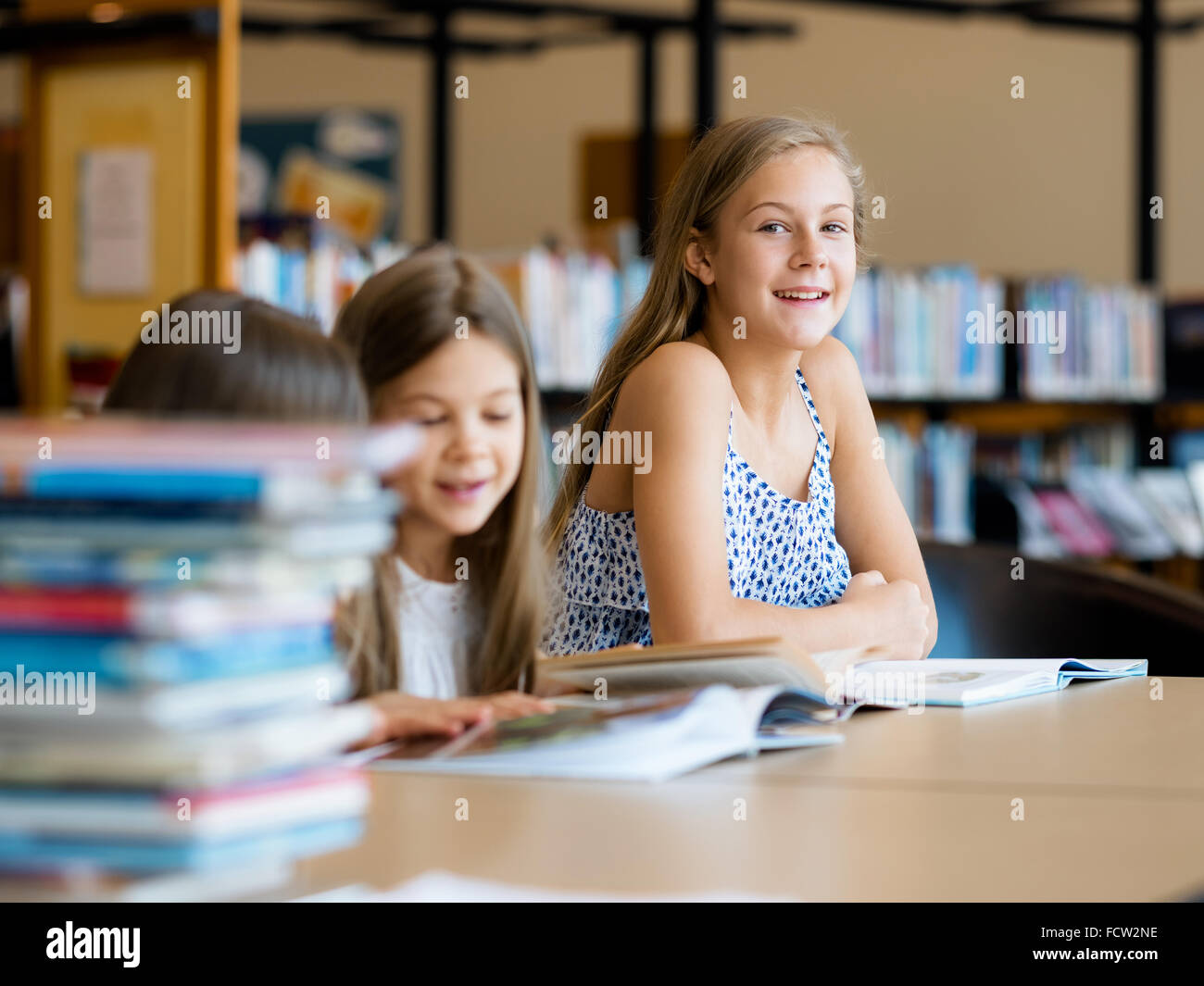 Little girls reading books in library Stock Photo - Alamy