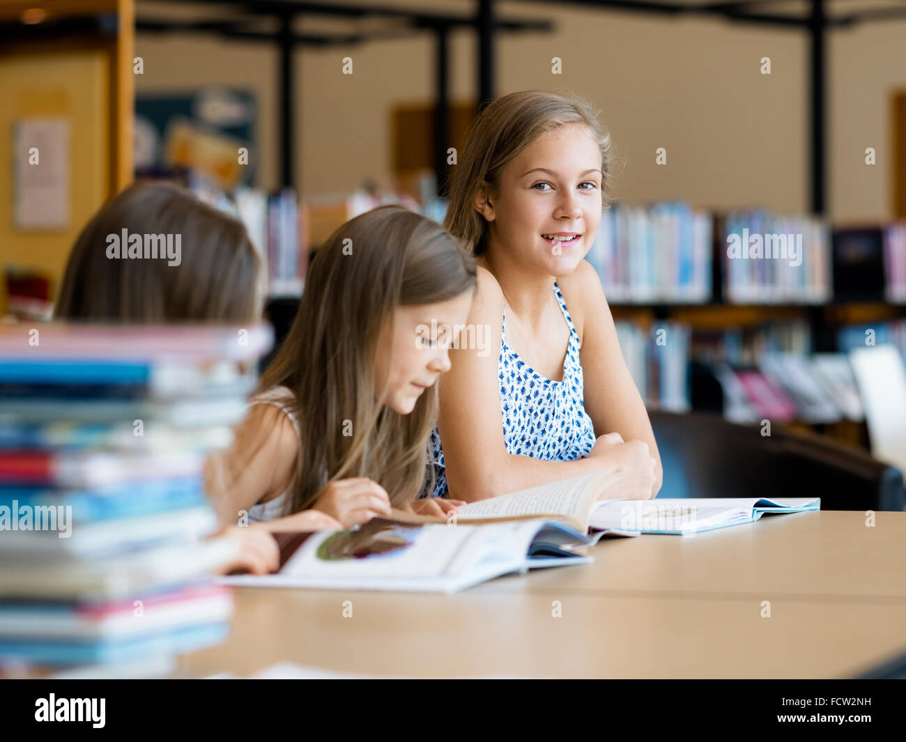 Little girls reading books in library Stock Photo - Alamy