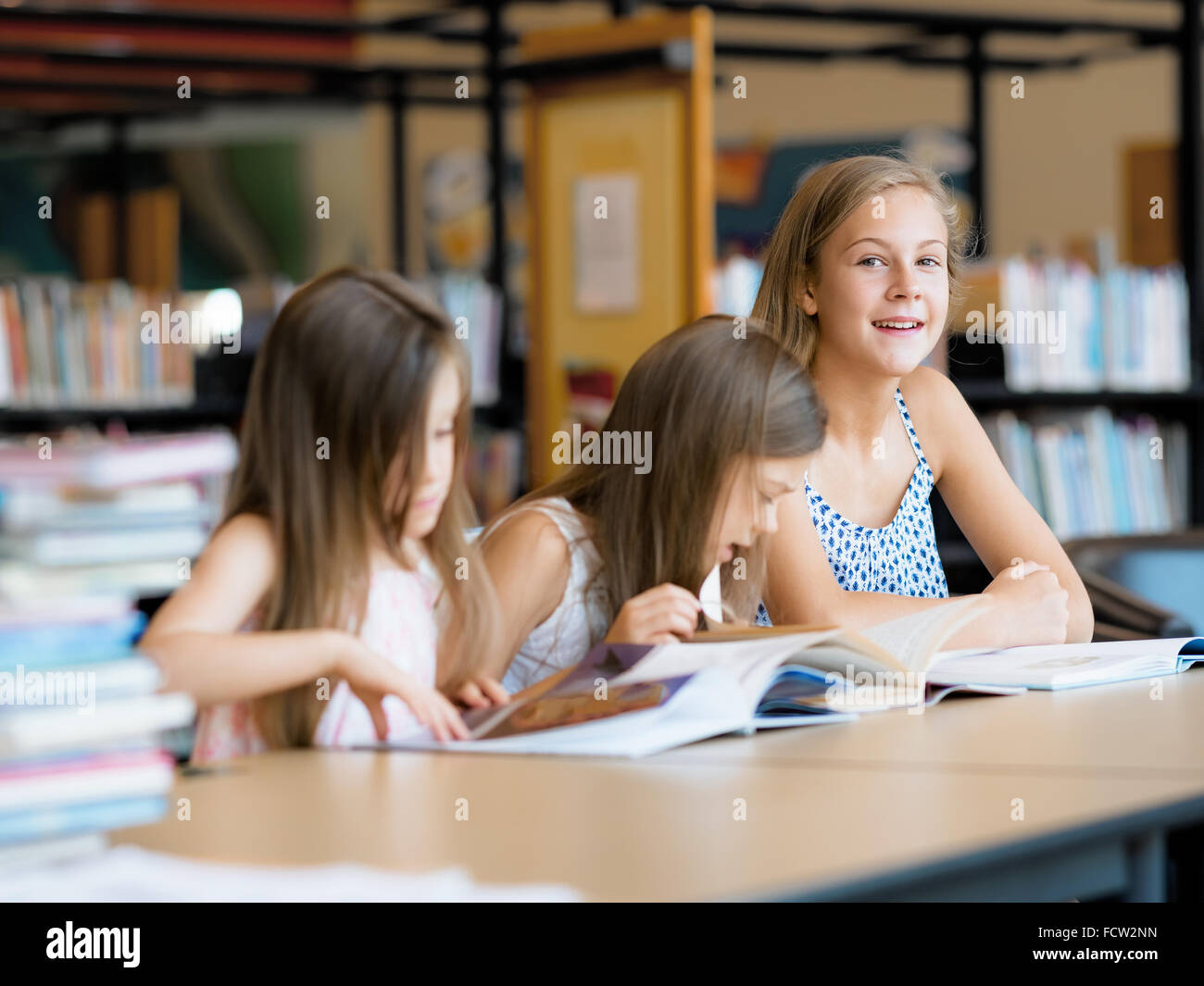 Little girls reading books in library Stock Photo - Alamy
