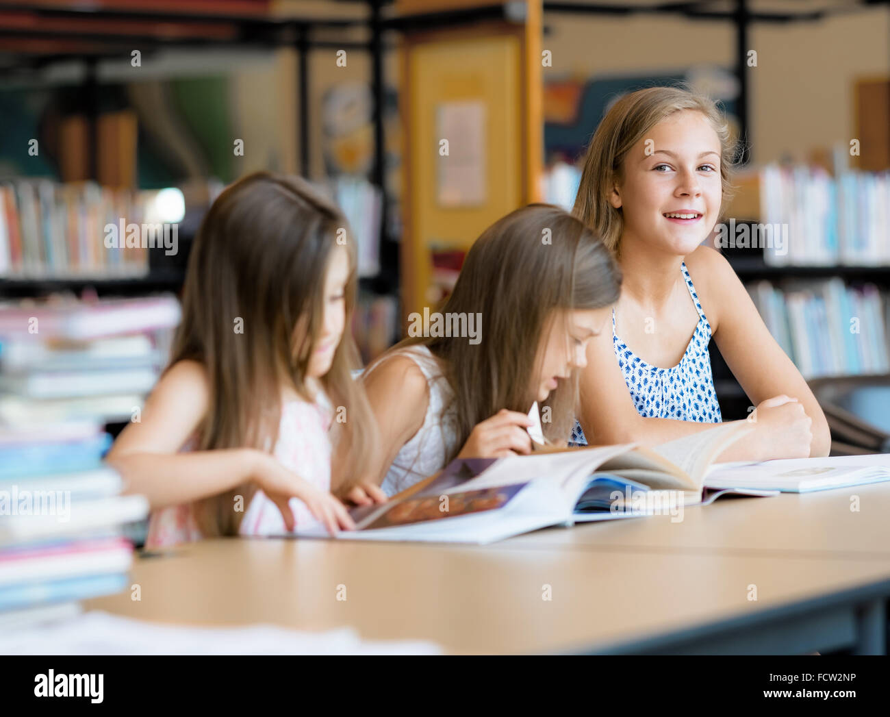 Little girls reading books in library Stock Photo - Alamy