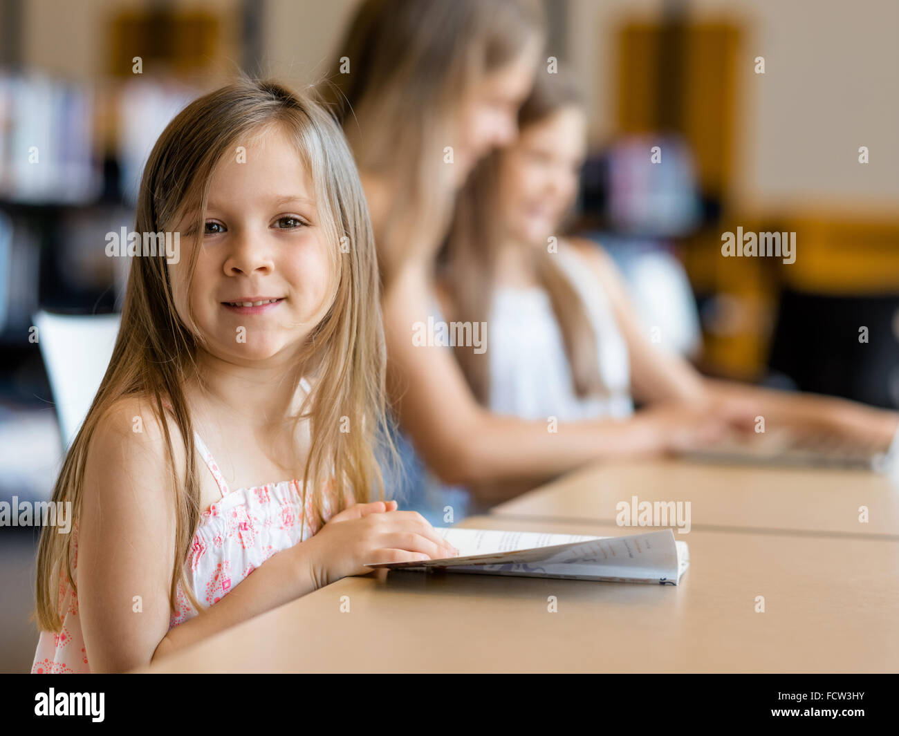 Little girls reading books in library Stock Photo - Alamy